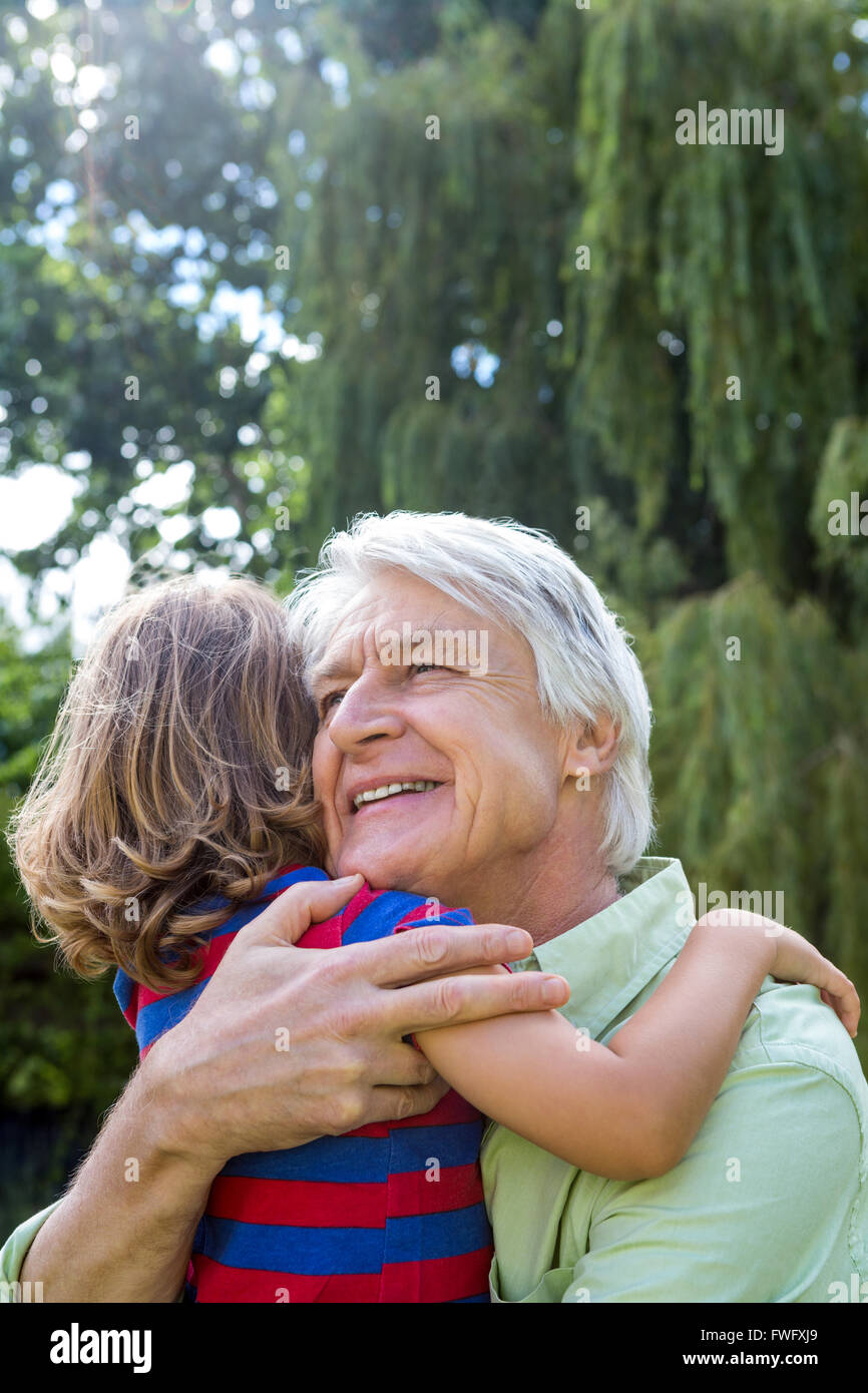 Happy grandfather hugging grandson at yard Stock Photo - Alamy