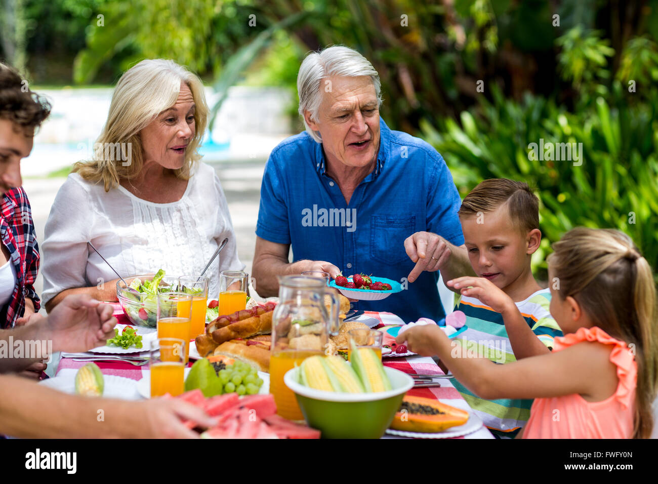 Granparents having breakfast with family at yard Stock Photo - Alamy