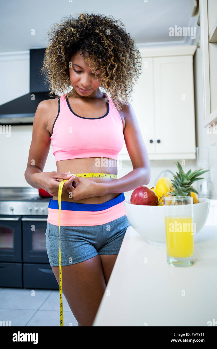 Woman measuring her waist Stock Photo - Alamy