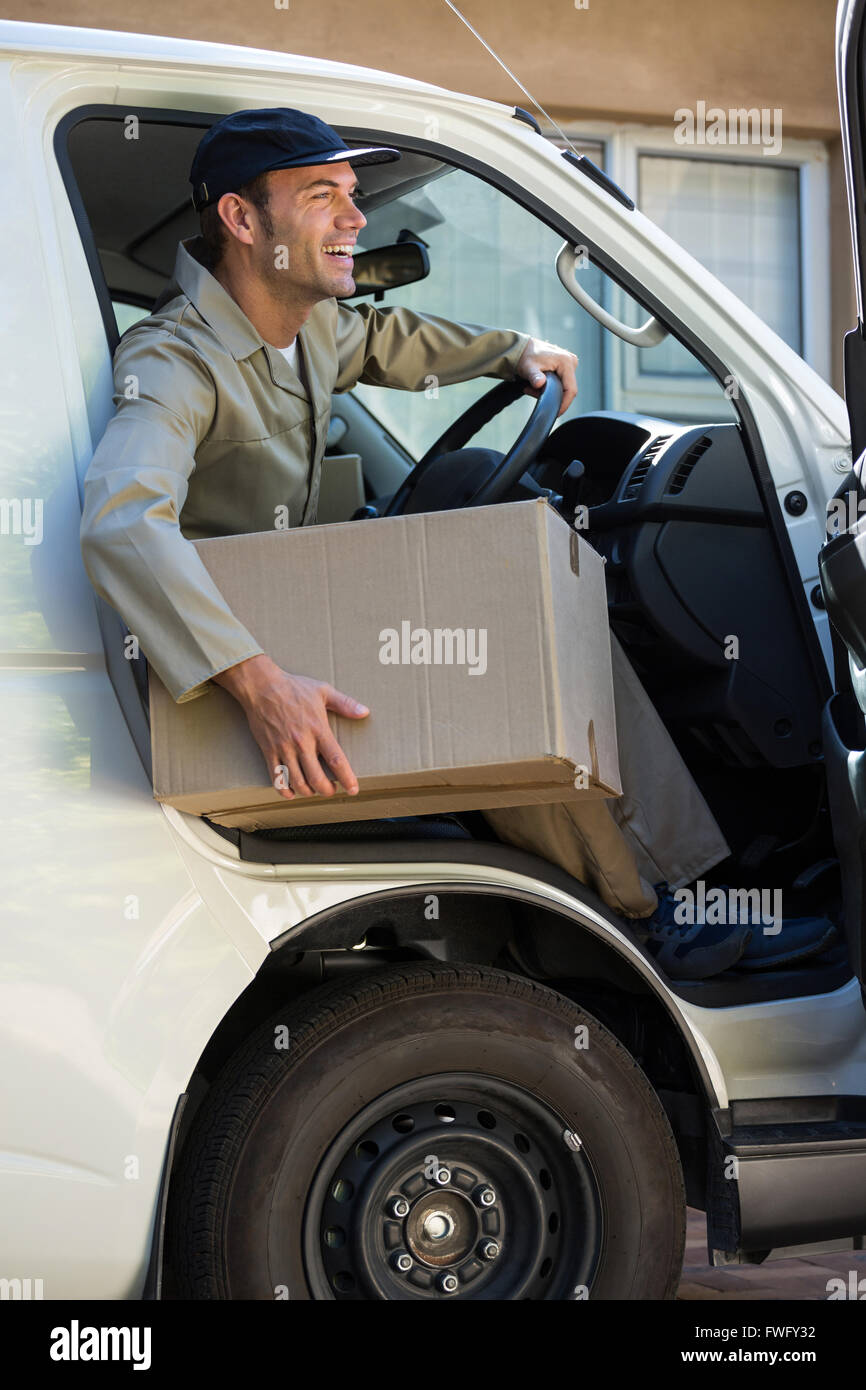 Smiling delivery man getting out from van Stock Photo - Alamy