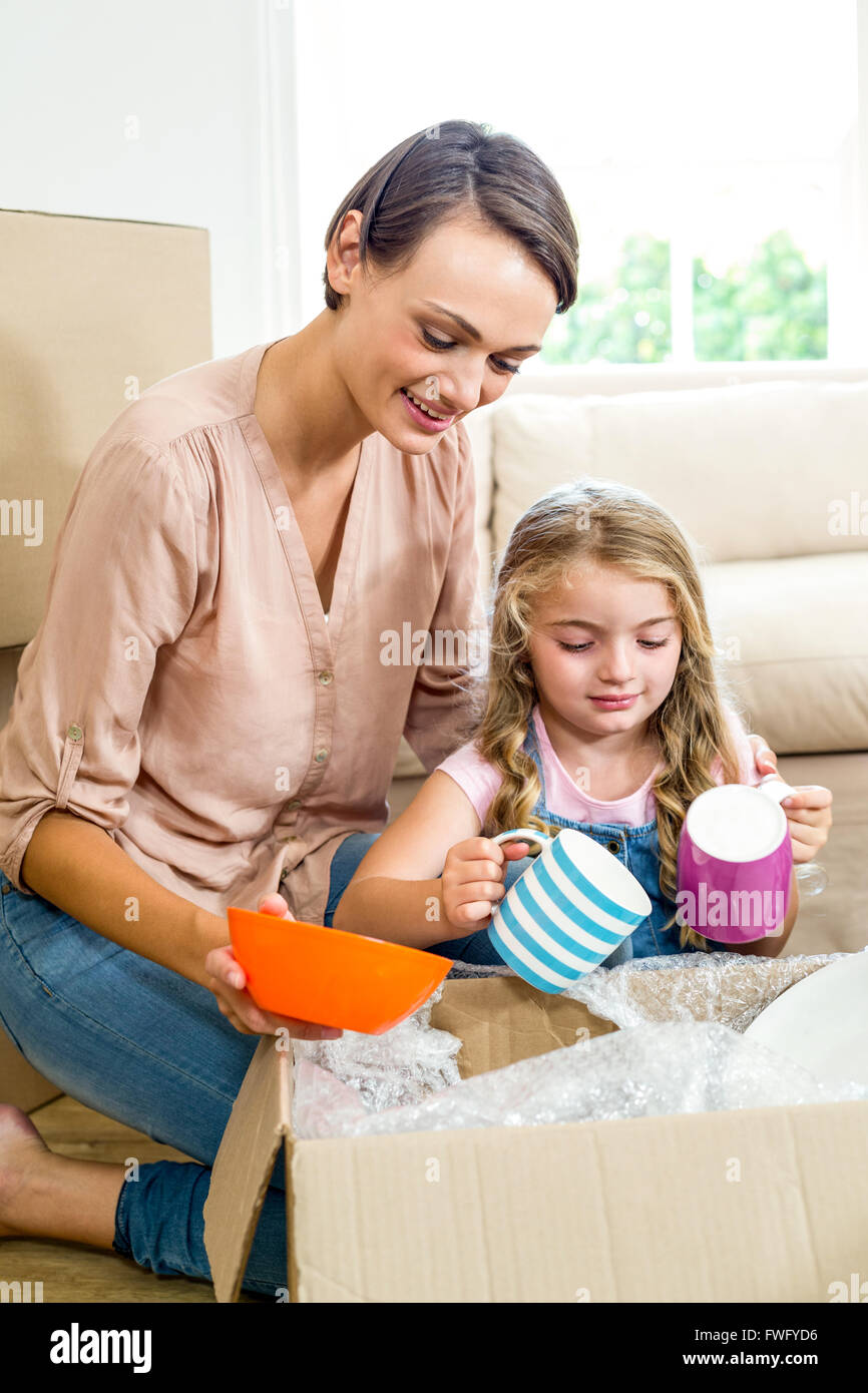 Mother and daughter removing containers from box Stock Photo - Alamy