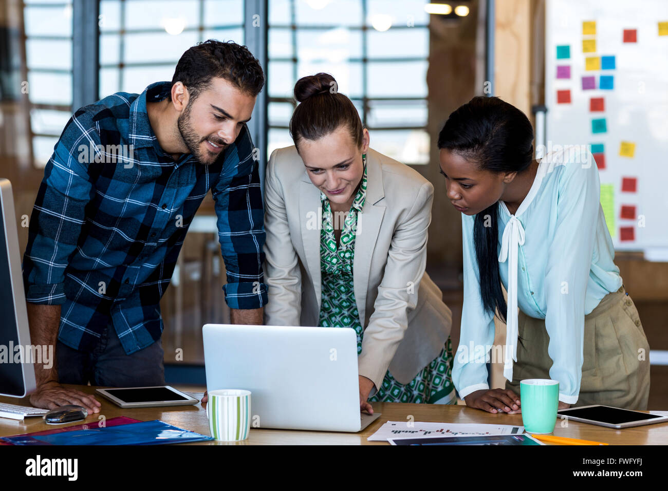 Young man and women discussing using laptop Stock Photo - Alamy