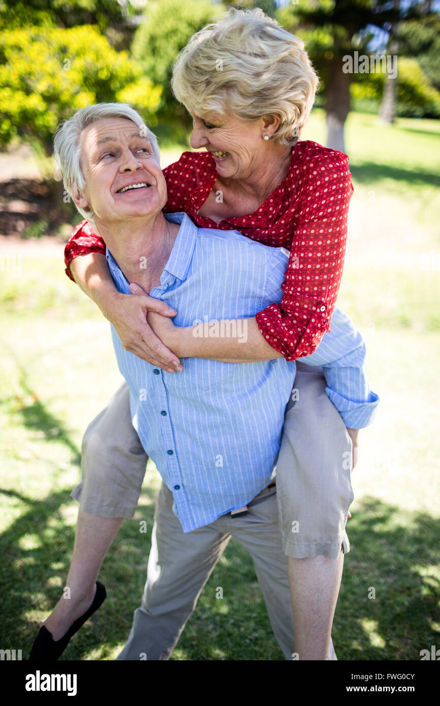 Happy senior man giving a piggy back to senior woman Stock Photo - Alamy