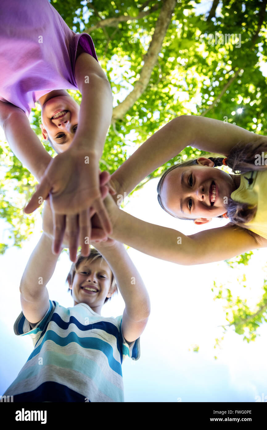 Portrait of happy children putting their hands together Stock Photo - Alamy