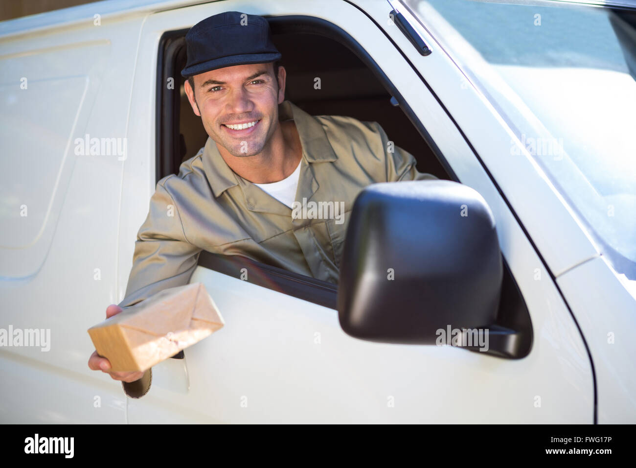 Smiling delivery man sitting in his van Stock Photo - Alamy