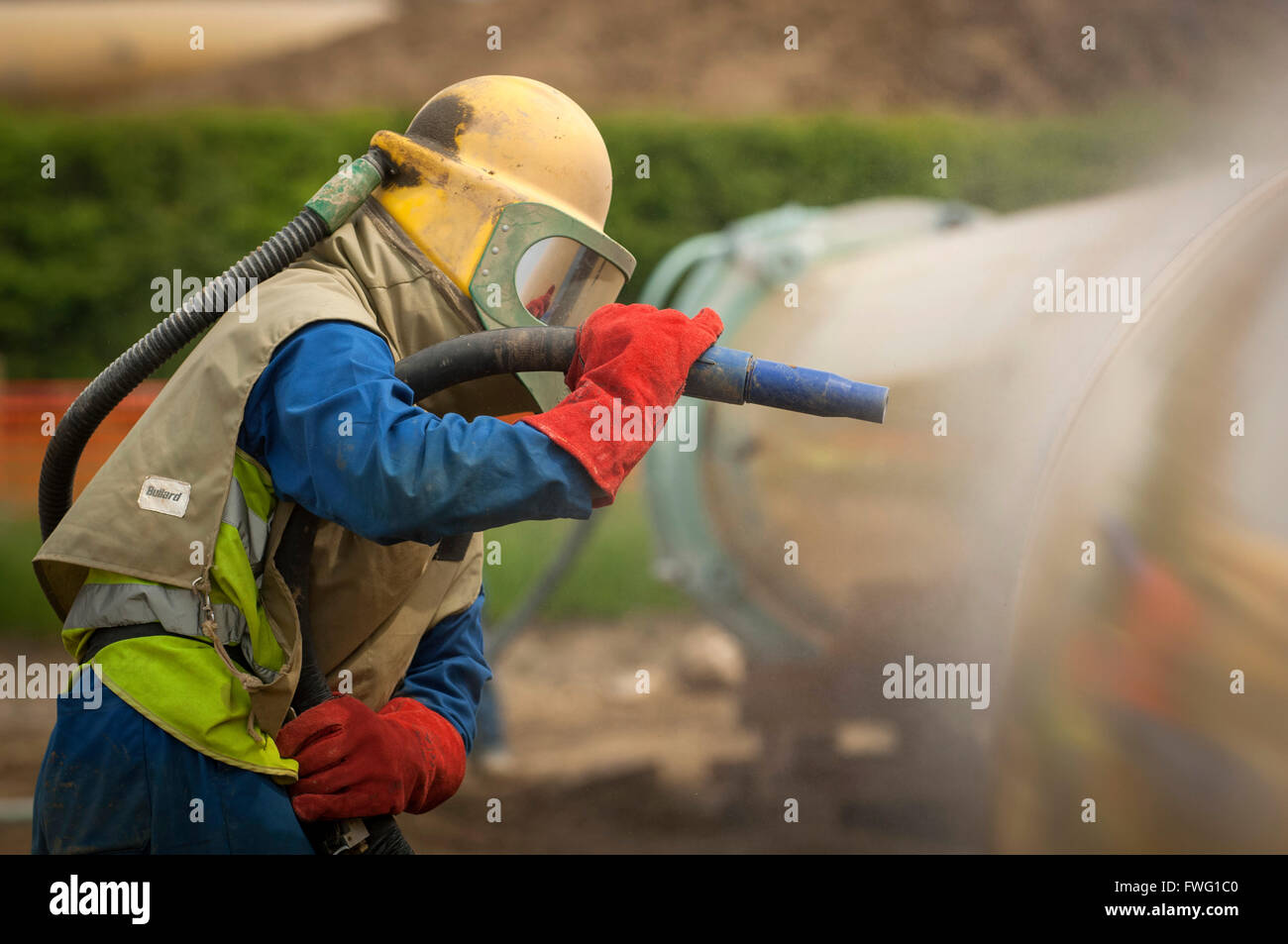 A sand blaster in protective clothing at work in the UK Stock Photo - Alamy