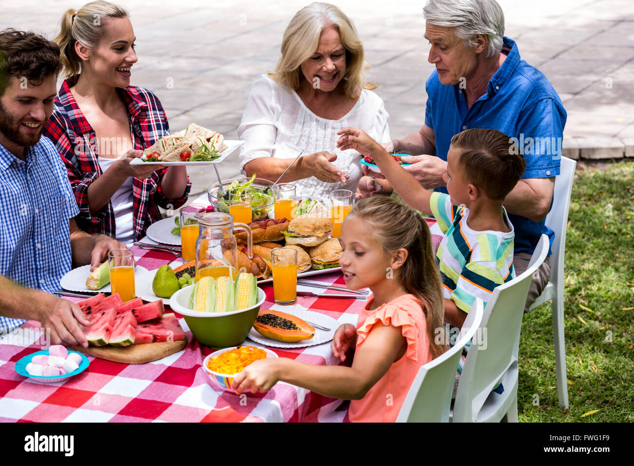 Happy family having lunch at lawn Stock Photo - Alamy