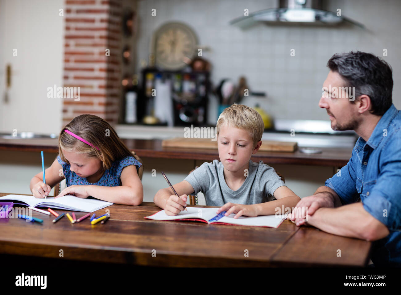 Father helping kids with their homework Stock Photo - Alamy