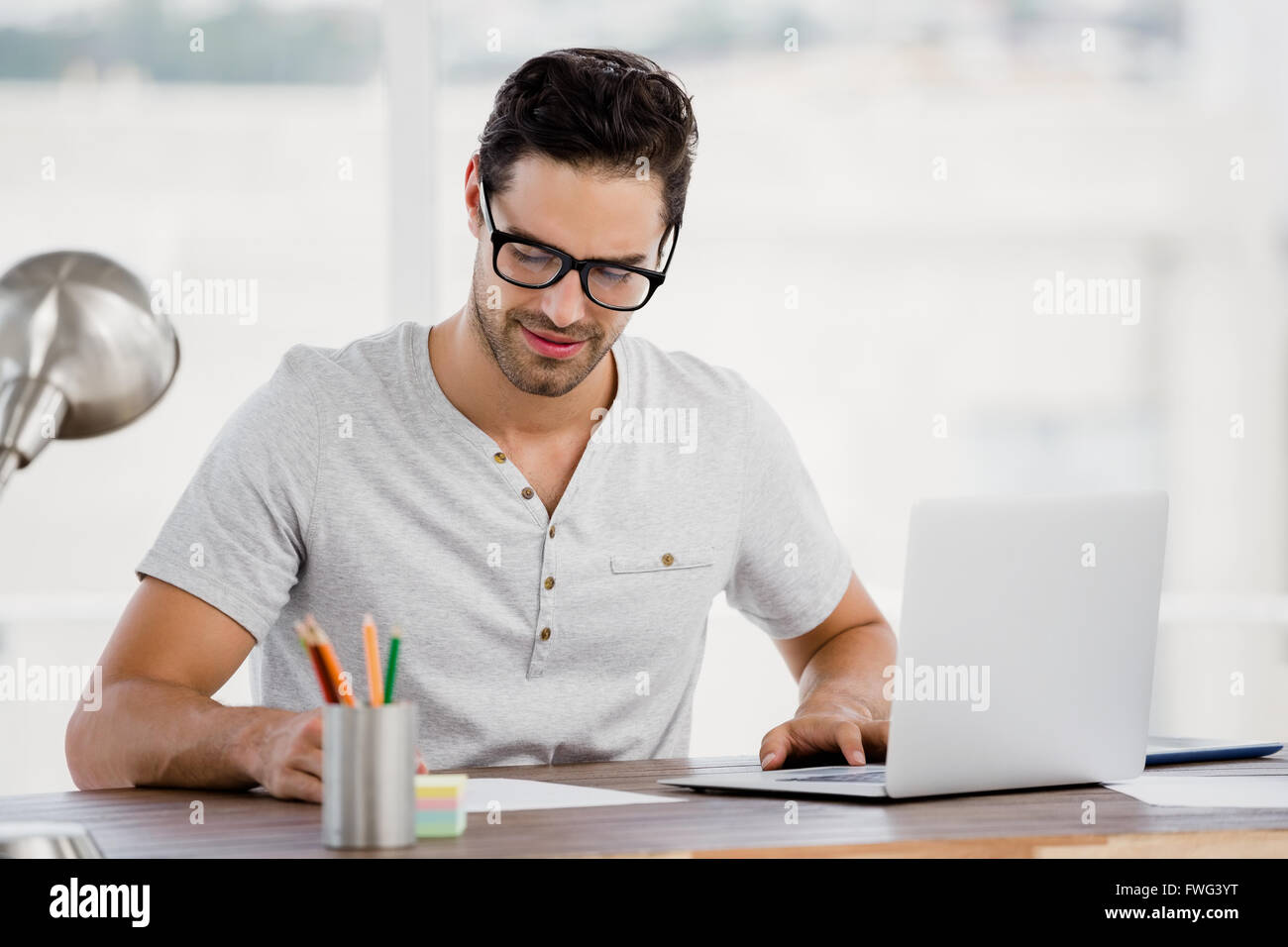 Young man working at his desk Stock Photo - Alamy