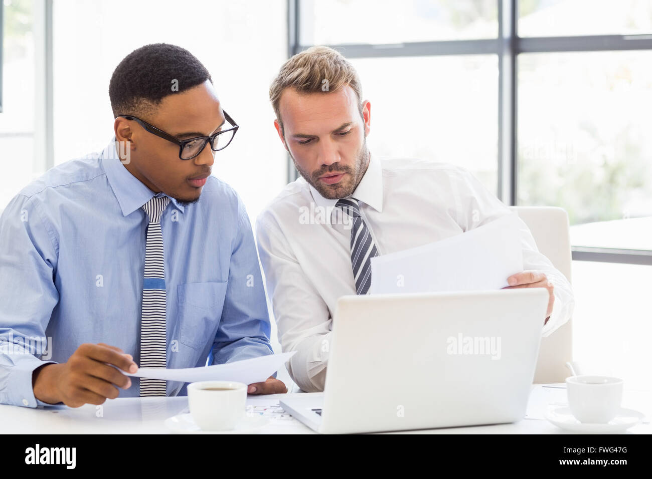 Businessmen discussing a report Stock Photo - Alamy