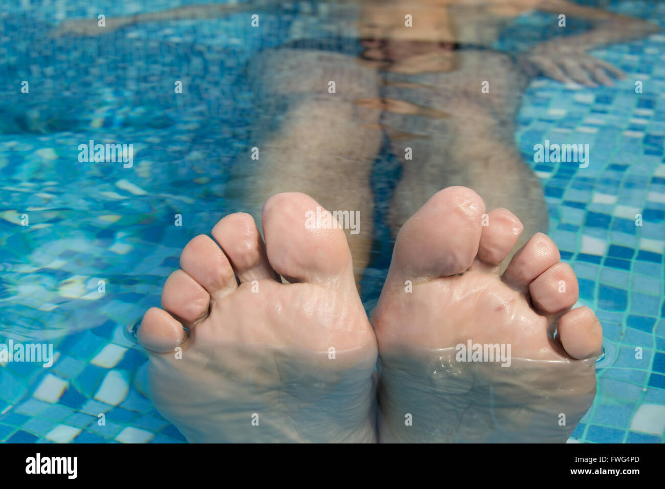Toes in the blue water in the pool Stock Photo - Alamy