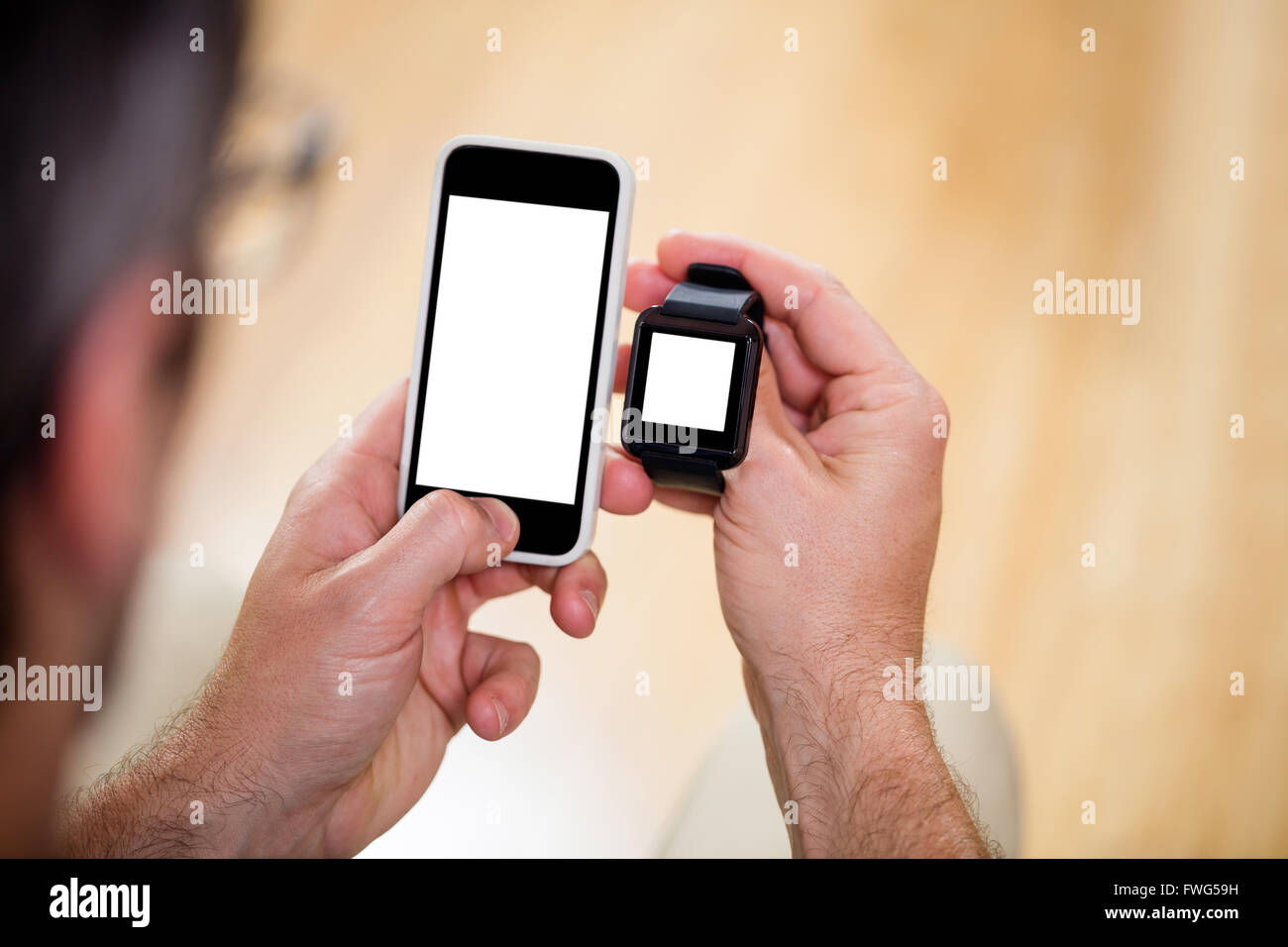 Mans hand holding a smart watch and a mobile phone Stock Photo - Alamy