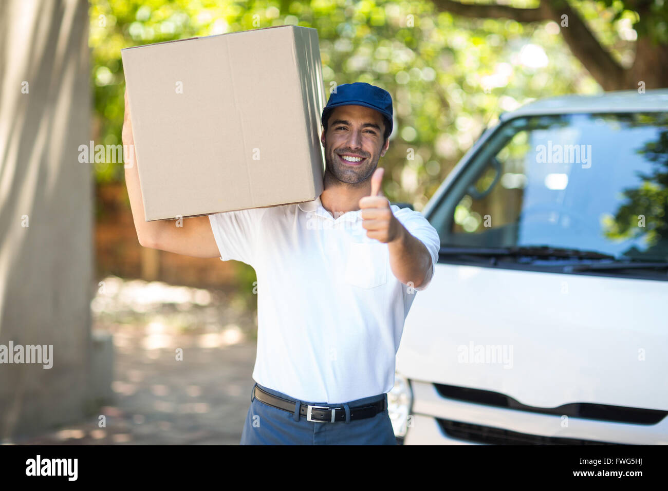 Portrait of smiling delivery man showing thumbs up Stock Photo - Alamy