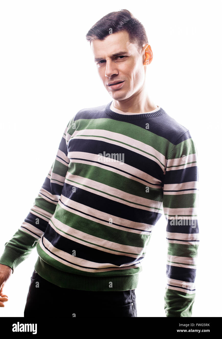 Portrait of a smart serious young man standing against white background ...