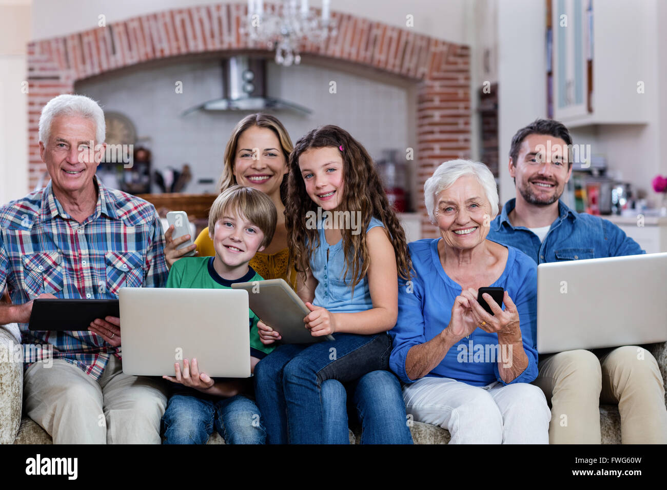Multi-generation family using a laptop, tablet and phone Stock Photo ...