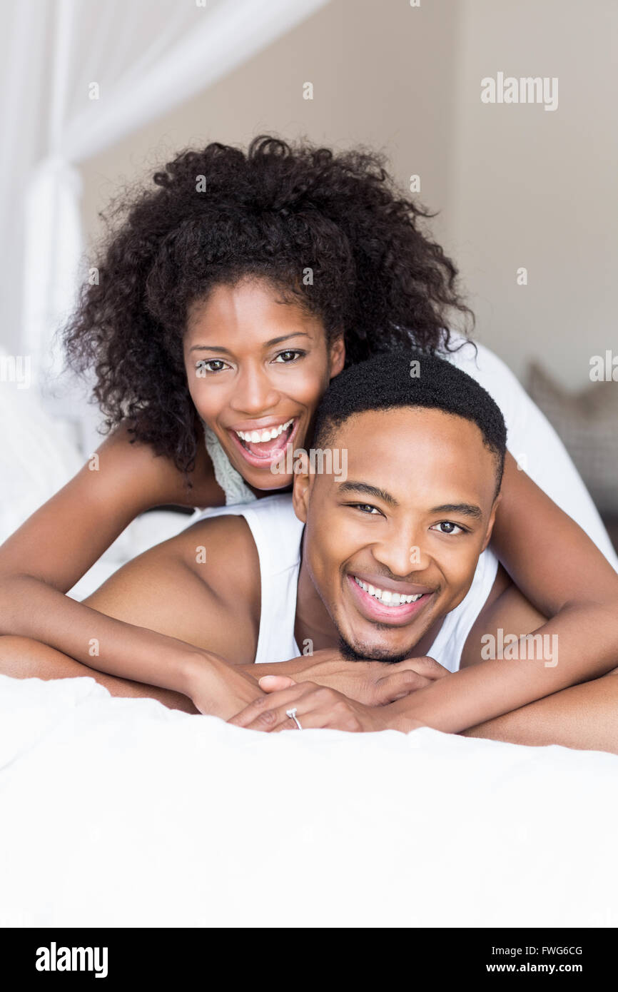 Young couple lying on bed and embracing each other Stock Photo - Alamy