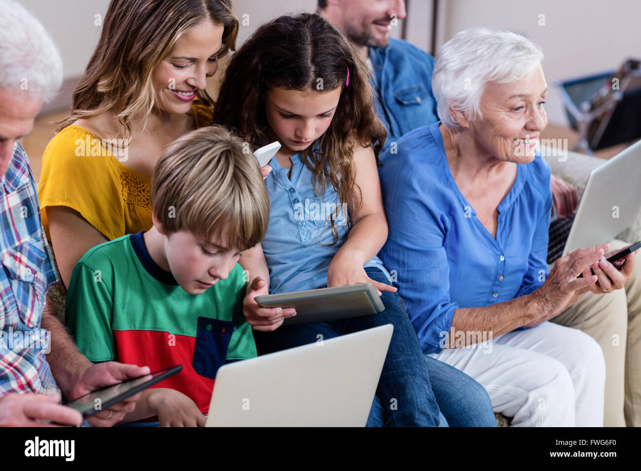 Multi-generation family using a laptop, tablet and phone Stock Photo ...
