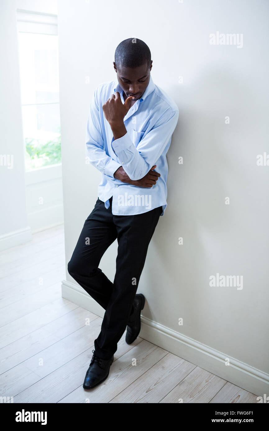 Tensed man leaning on wall Stock Photo - Alamy