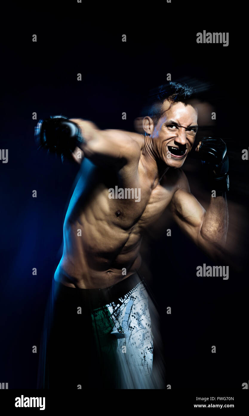 young man punching with determination, black background Stock Photo - Alamy