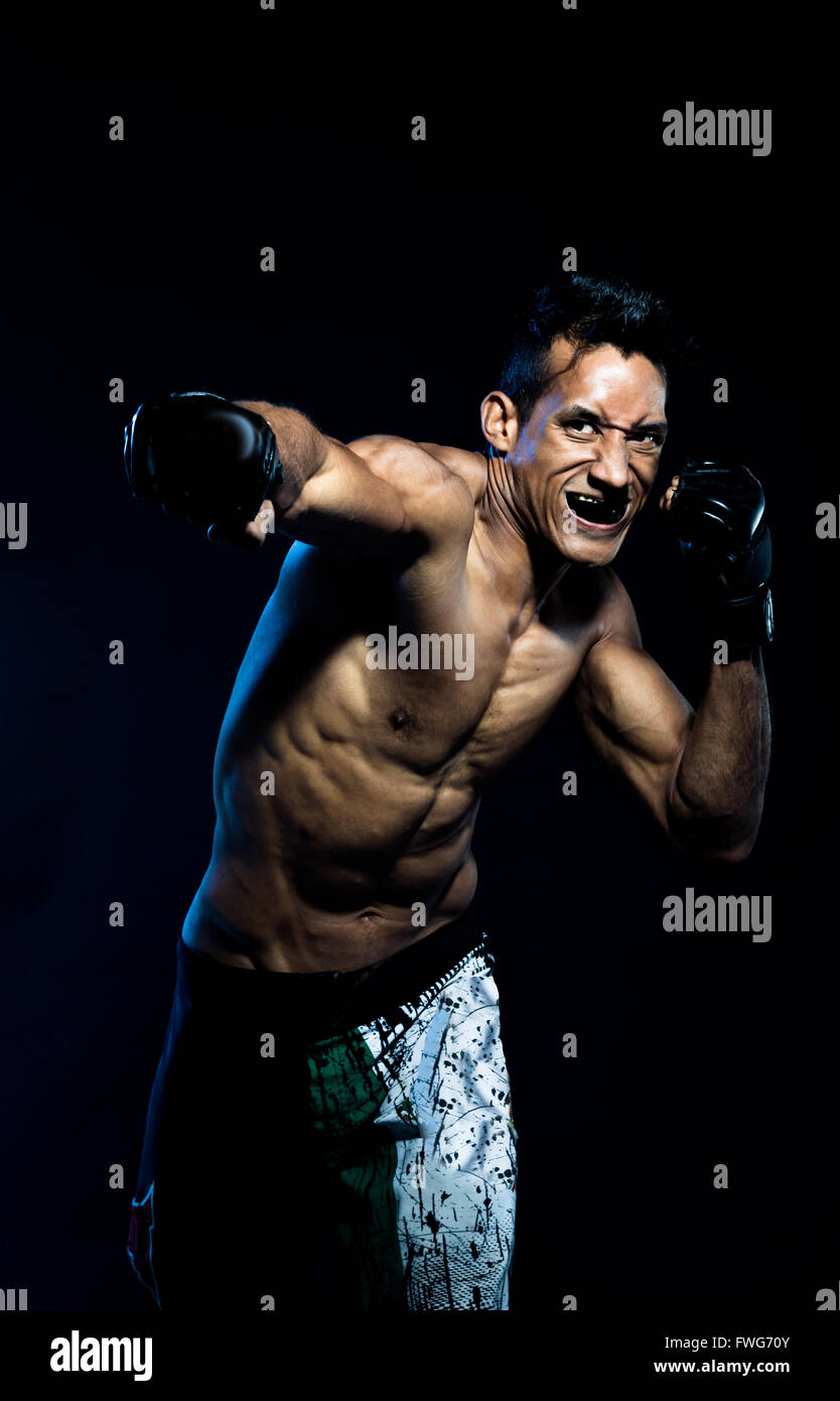 young man punching with determination, black background Stock Photo - Alamy