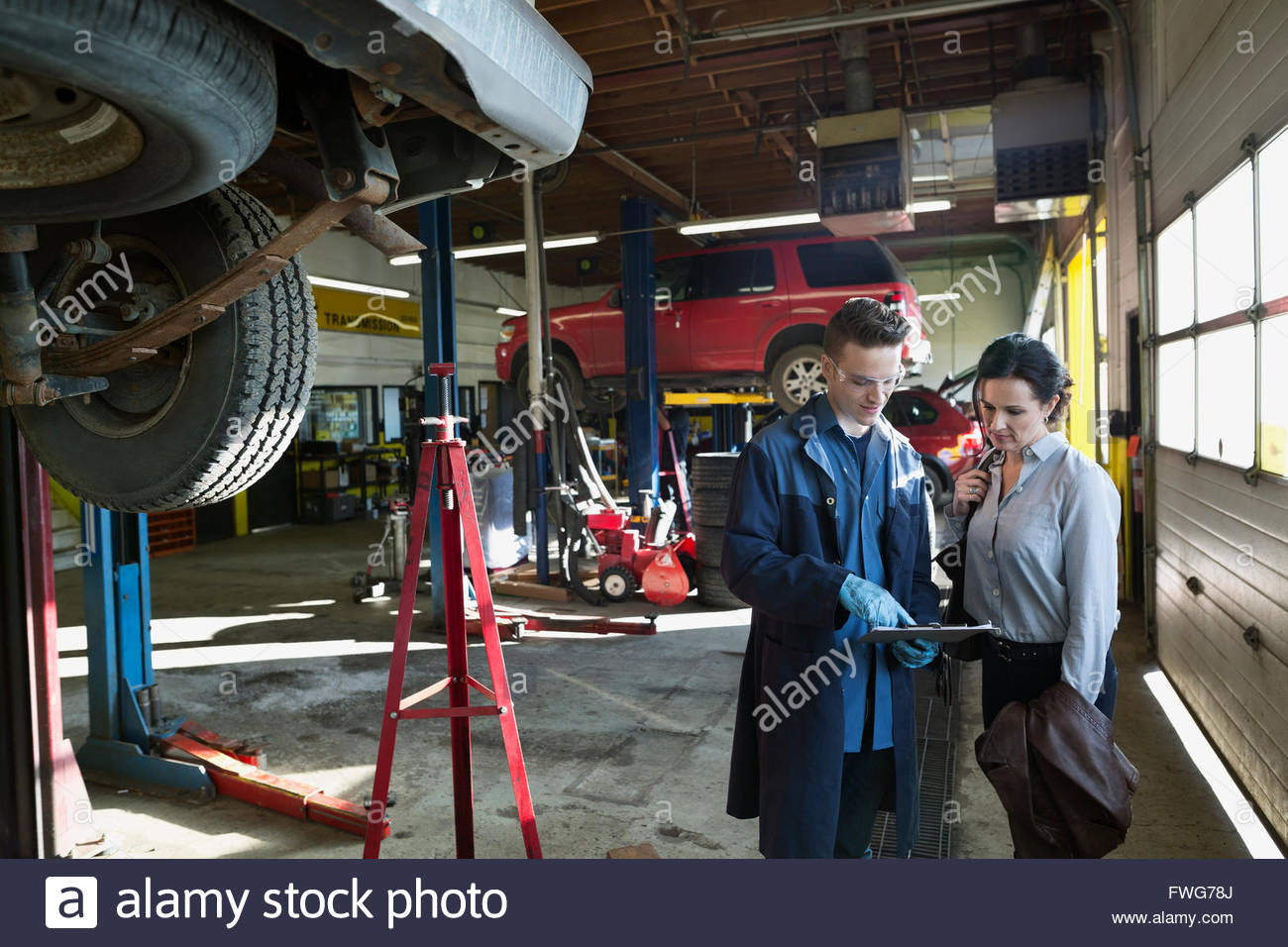 Mechanic with clipboard explaining customer auto repair shop Stock ...