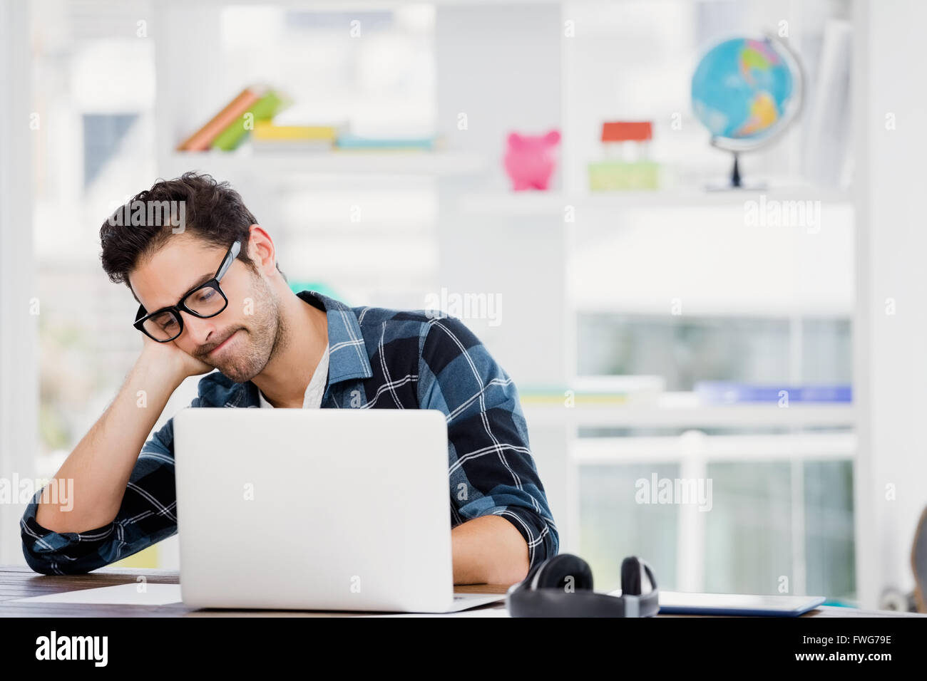 Stressed young man sitting at his desk Stock Photo - Alamy