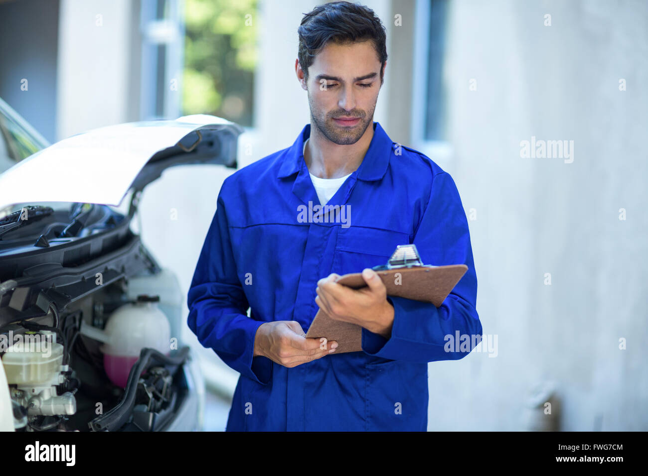 Front view of technician checking clipboard Stock Photo - Alamy