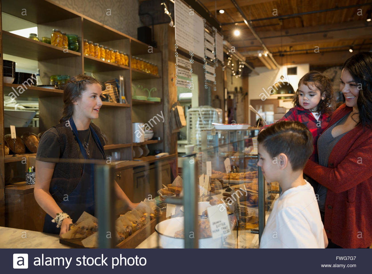 Bakery worker serving family Stock Photo - Alamy