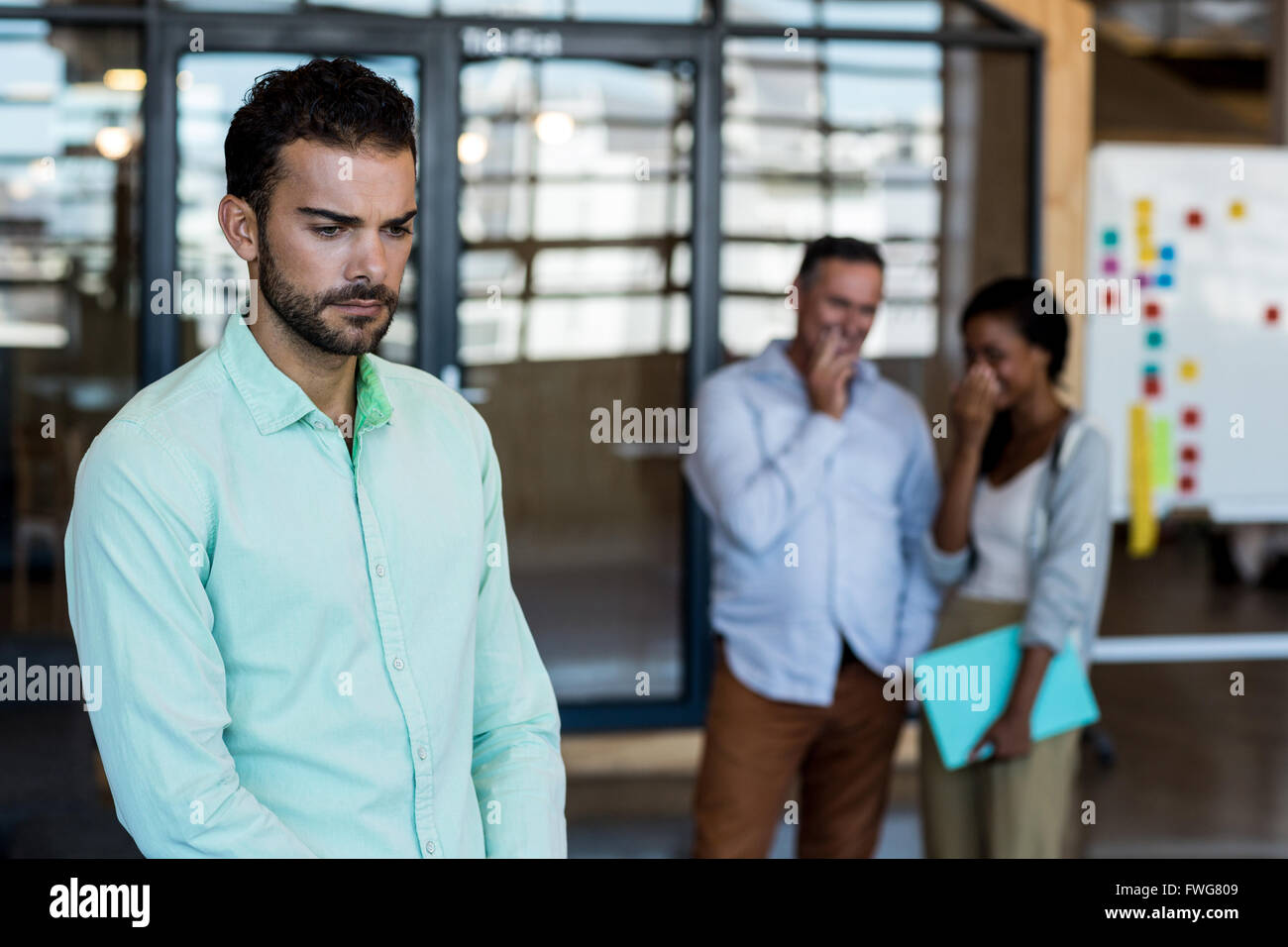 Depressed young man standing in the office Stock Photo - Alamy