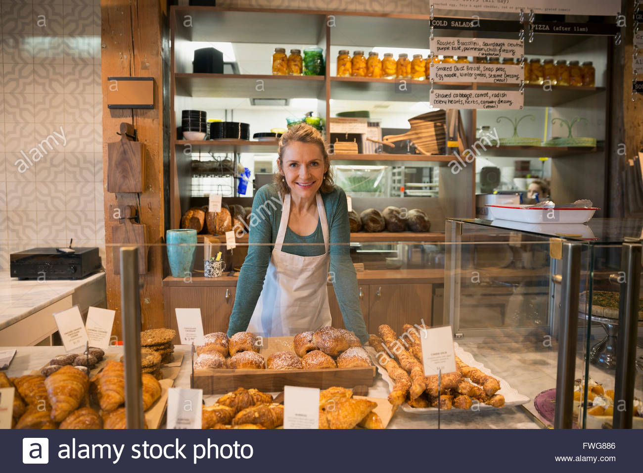 Woman smiling behind bakery counter hi-res stock photography and images ...