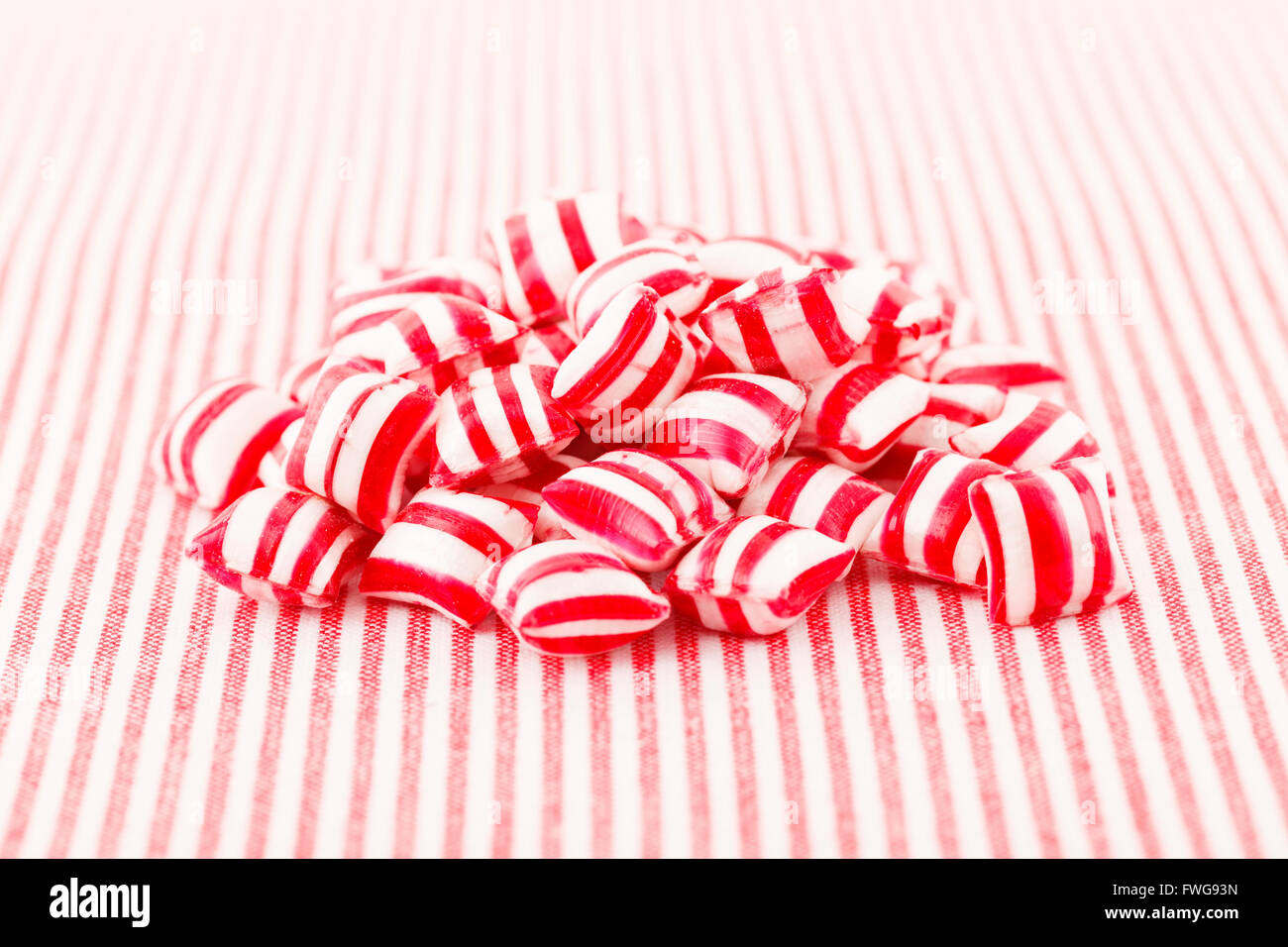 Red and white sweets on striped background Stock Photo - Alamy