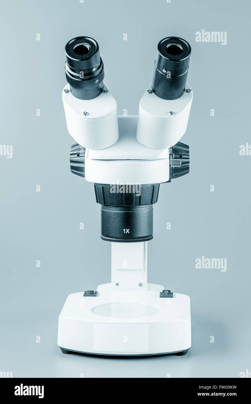 Laboratory microscope against a grey background Stock Photo - Alamy