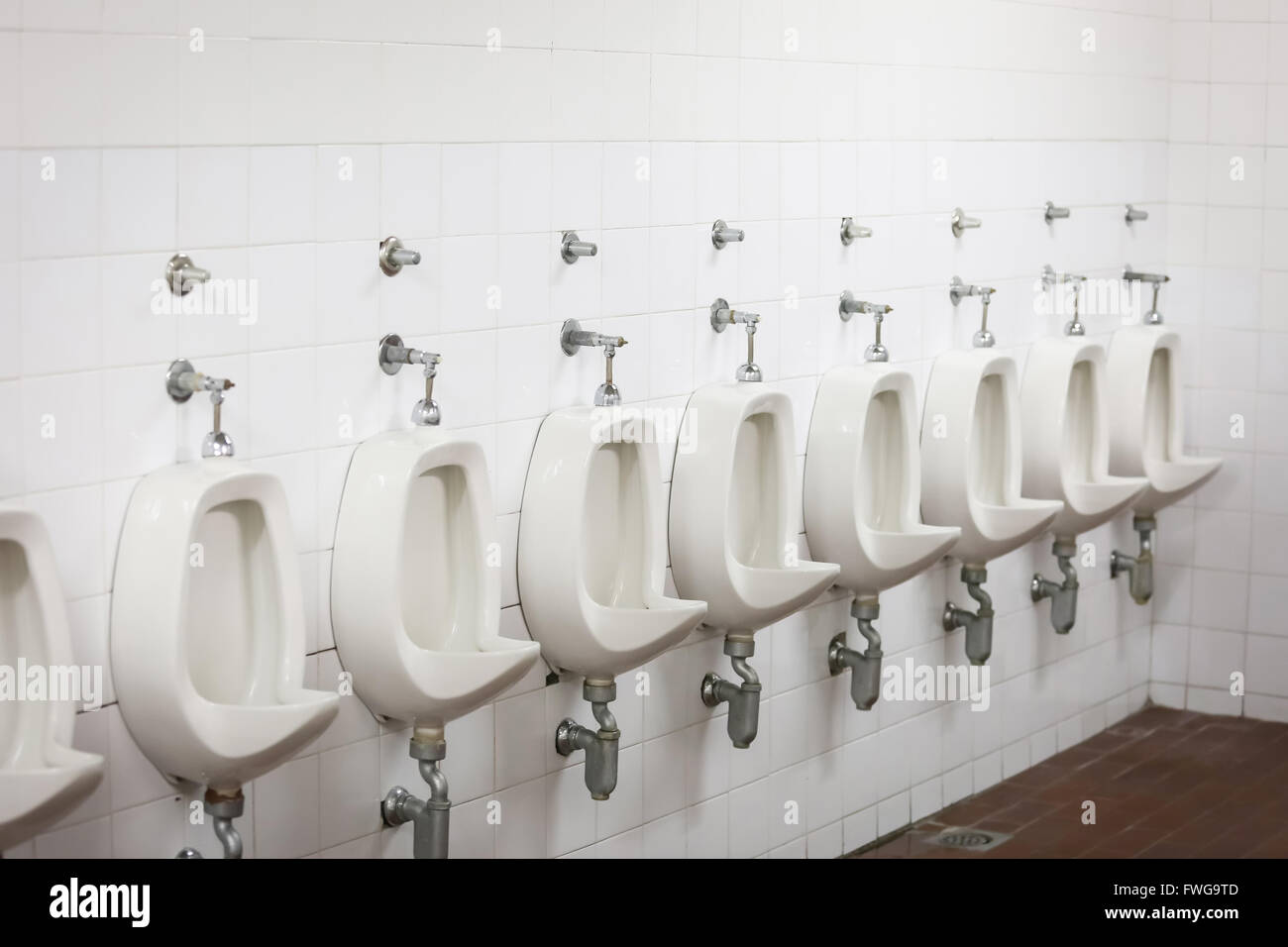 A row of urinals in a public restroom Stock Photo - Alamy