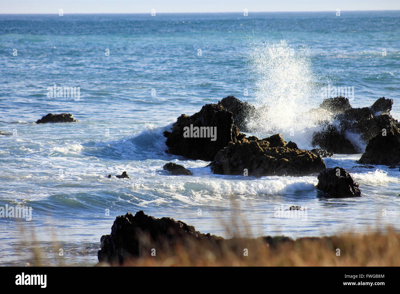 Wave Breaking on Rocks Stock Photo - Alamy