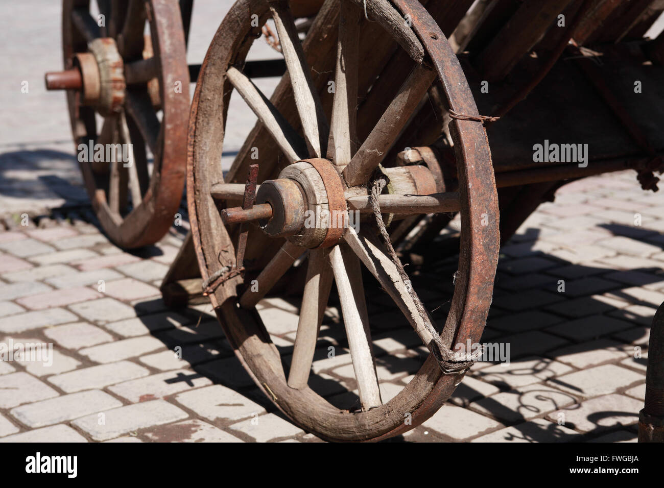 Closeup of old dray wheels on pavement under sunlight Stock Photo - Alamy