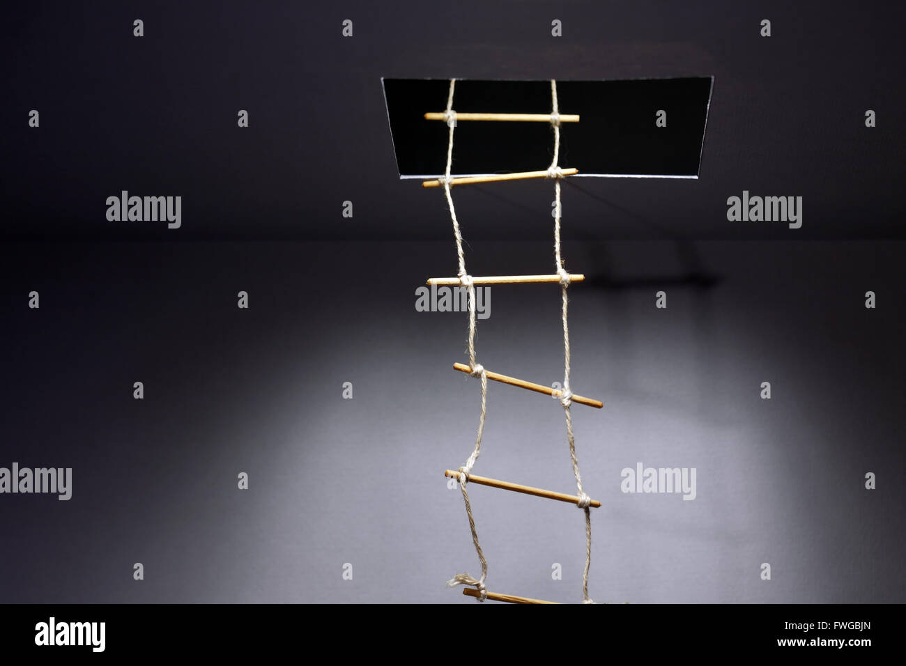 Escape concept. Rope ladder inside hatch in ceiling Stock Photo - Alamy