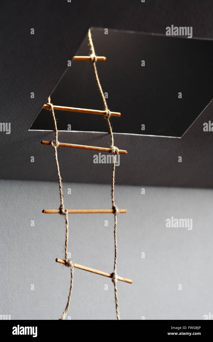 Escape concept. Rope ladder inside hatch in ceiling Stock Photo - Alamy