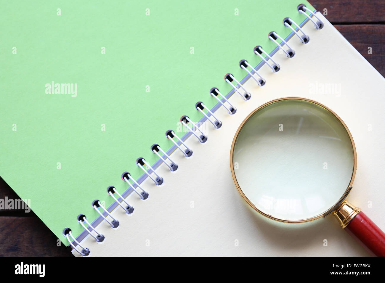 Investigation symbol. Magnifying glass on open spiral notebook with ...