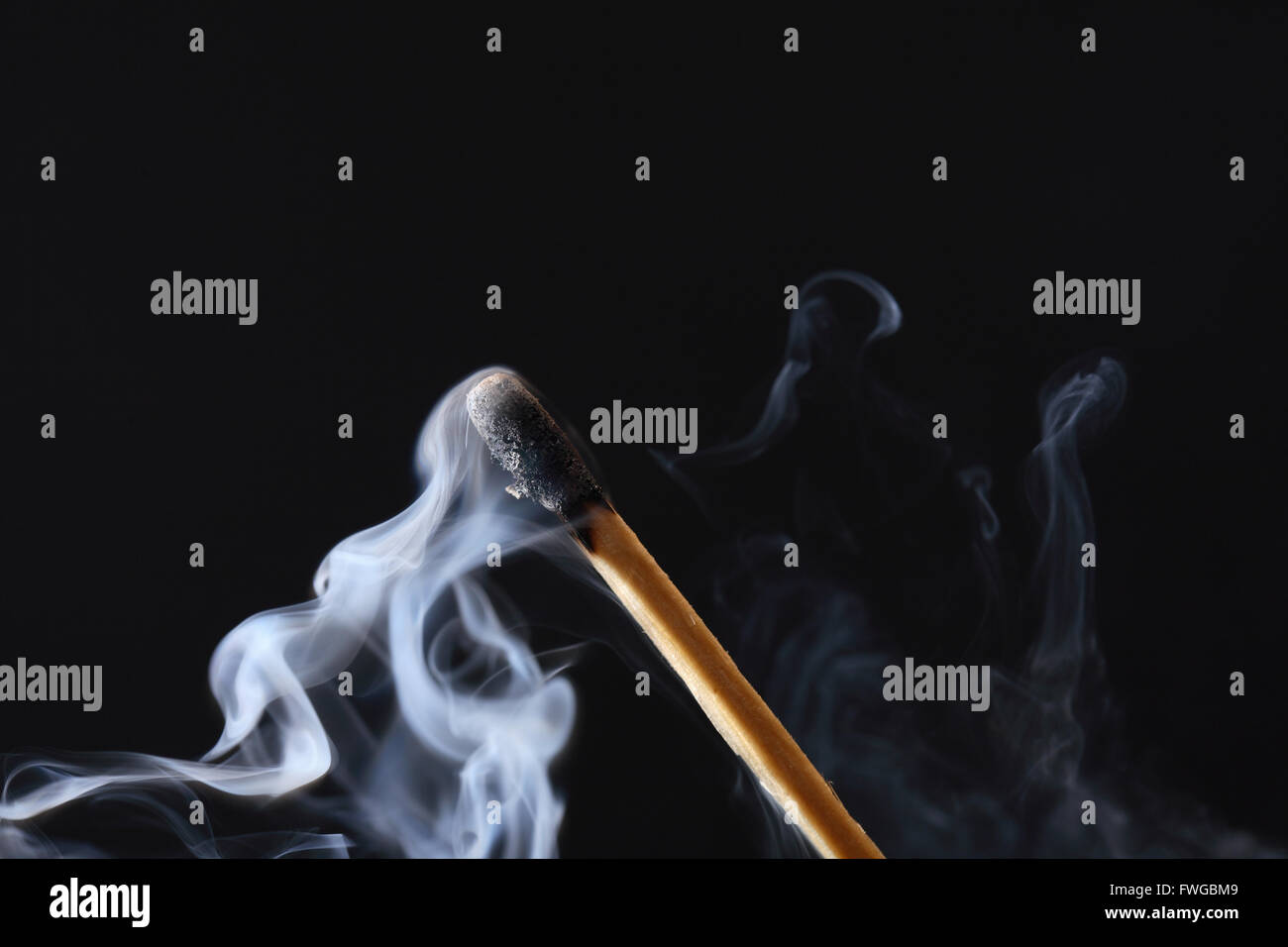 Extinguished match with nice smoke on dark background Stock Photo - Alamy