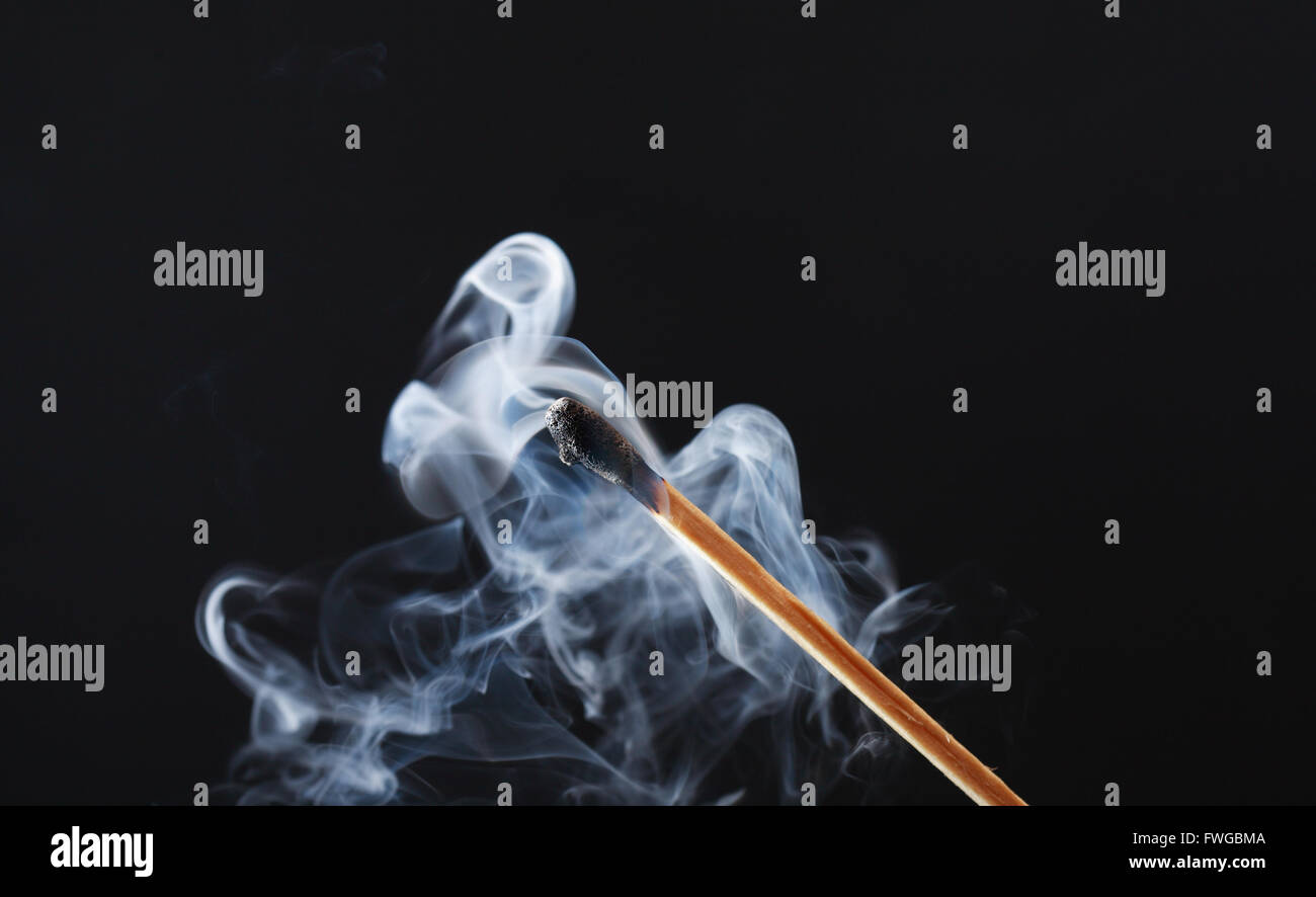 Extinguished match with nice smoke on dark background Stock Photo - Alamy
