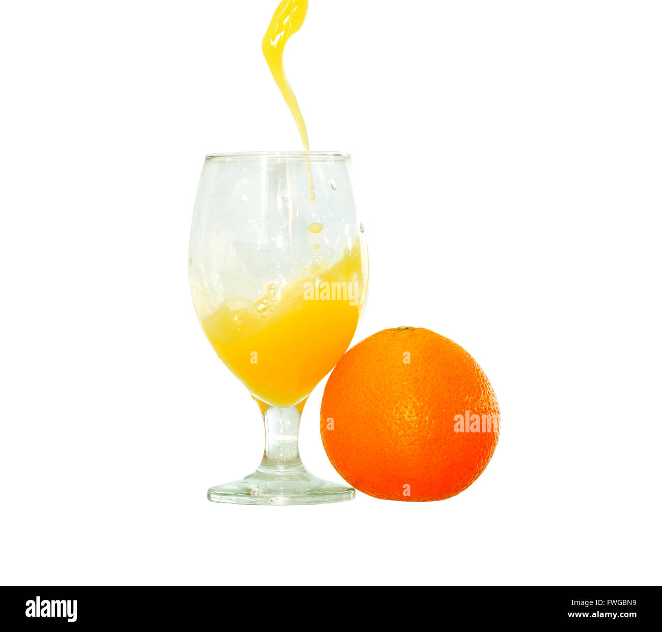 Orange juice flowing to glass on white background. Clipping path is ...