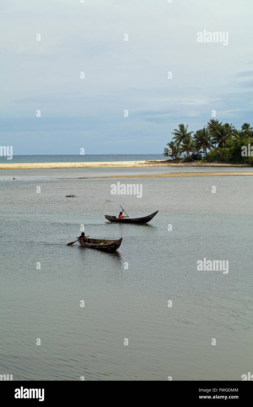Sambava Bay. Encamped fishing community. Boys using dugout canoes to ...