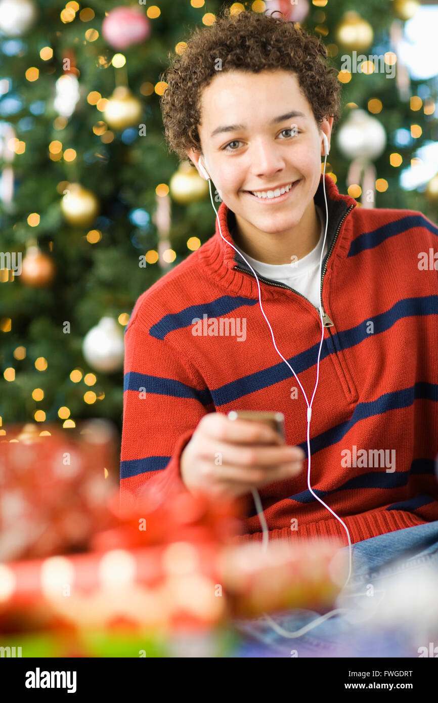 A boy in front of a Christmas tree, wearing headphones Stock Photo - Alamy