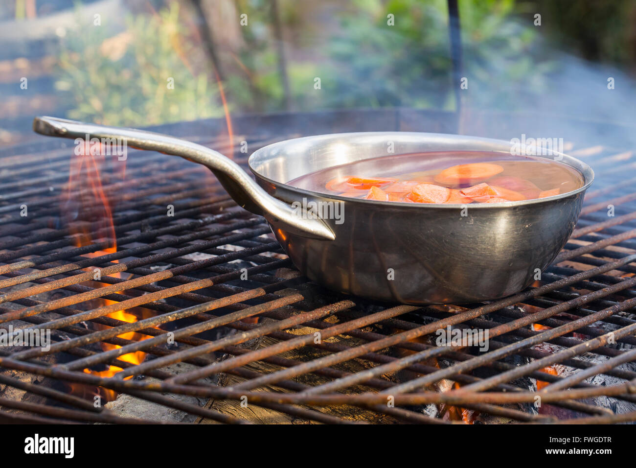 A small pan on a fire with blanched carrots Stock Photo - Alamy