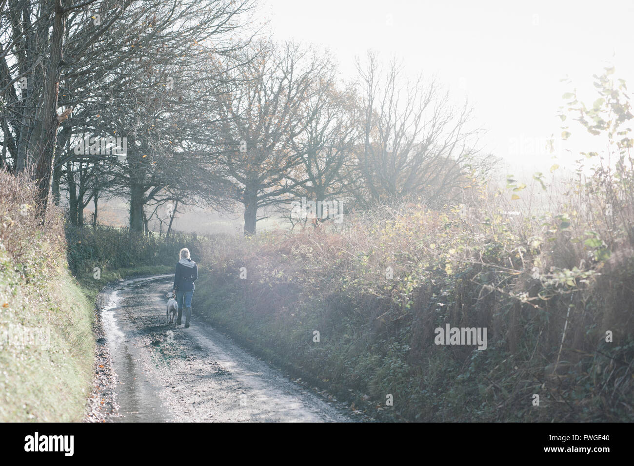 Woman walking down country lane hi-res stock photography and images - Alamy