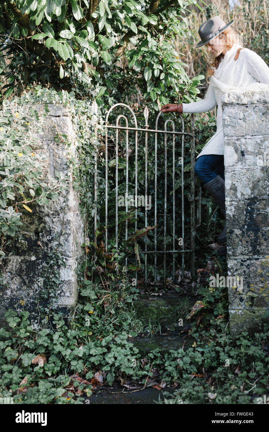 A woman opening a garden gate Stock Photo - Alamy
