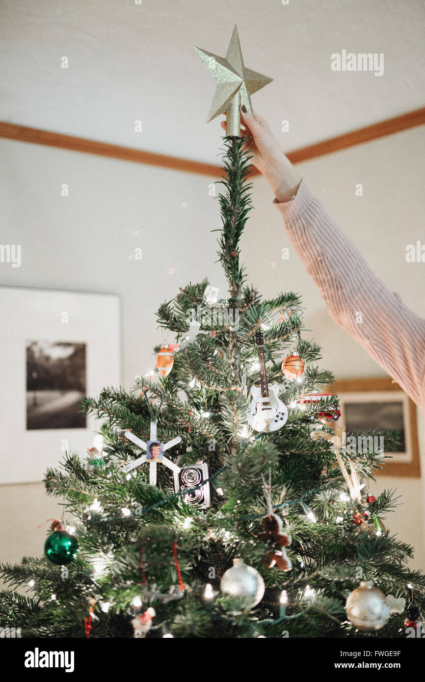 A person decorating a Christmas tree at home Stock Photo - Alamy