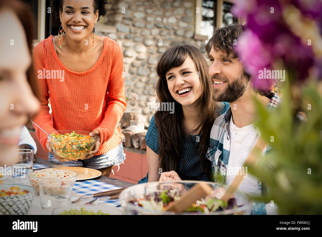 Friends around a table, men and women laughing and talking Stock Photo ...