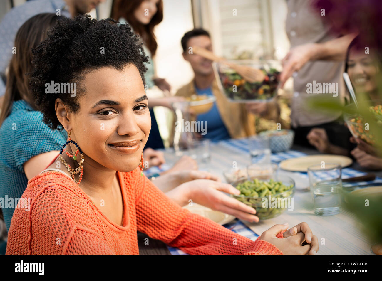 Friends around a table, men and women laughing and talking Stock Photo ...