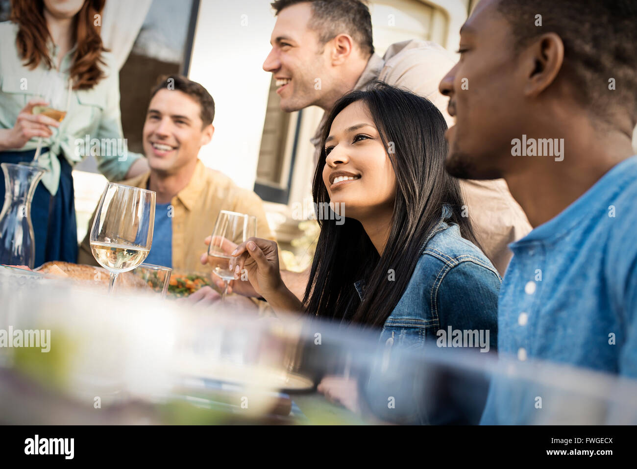 Friends around a table, men and women laughing and talking Stock Photo ...